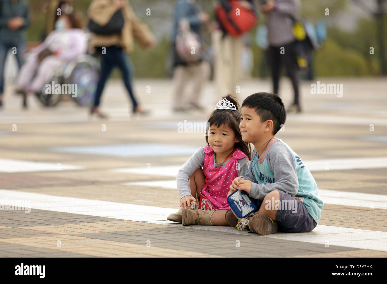 Two Japanese kids sitting in Osaka cosmo square, Japan Stock Photo - Alamy