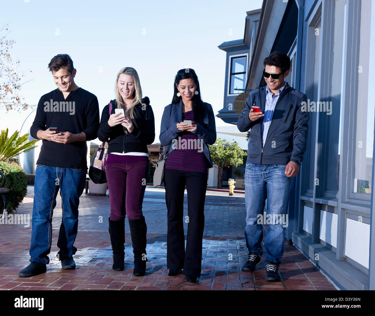 Friends using cell phones outdoors Stock Photo - Alamy