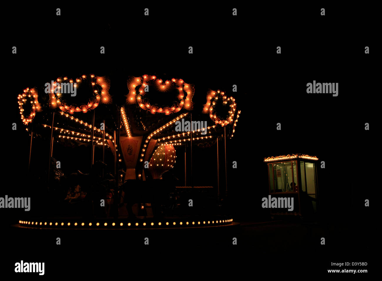 Carousel by night with ticket booth illuminated Stock Photo - Alamy