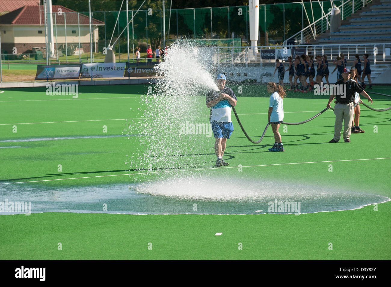 Groundstaff water the artificial pitch at Hartleyvale hockey stadium ...