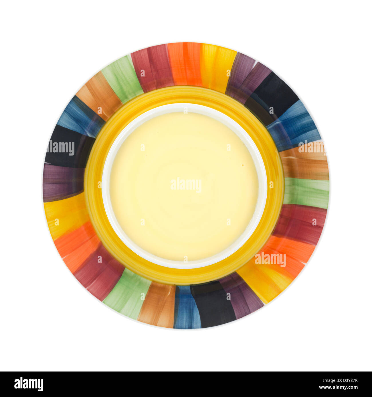 A bowl of freshly made cheddar cheese soup on a colorful plate Stock ...