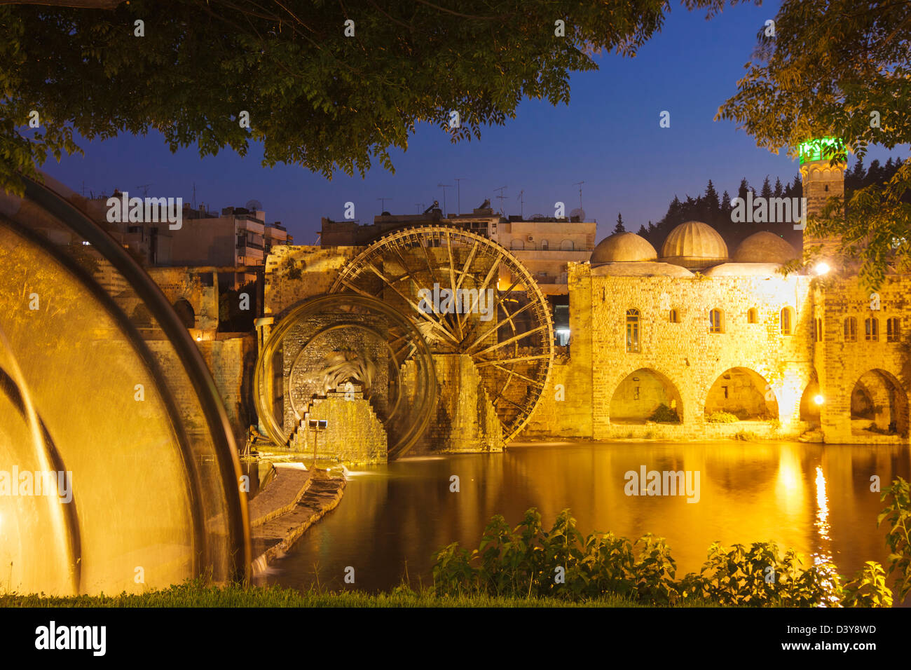 Norias and Nur al-Din mosque by the Orontes river in Hama, Syria Stock ...