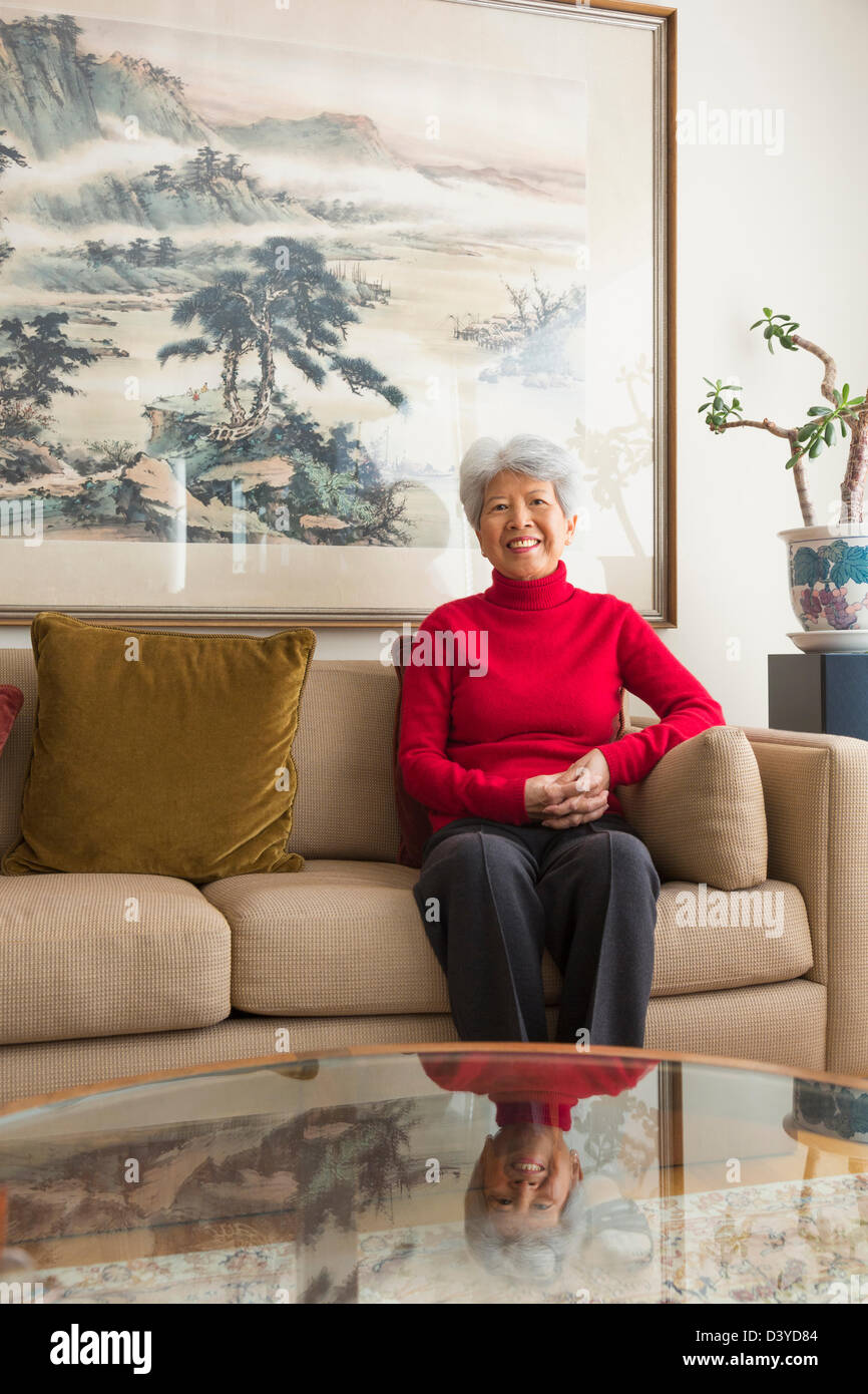 Chinese woman sitting on sofa Stock Photo - Alamy