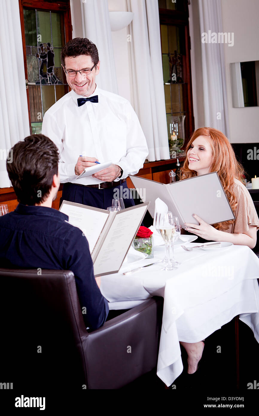 man and woman in restaurant waiter bring card and order food Stock ...
