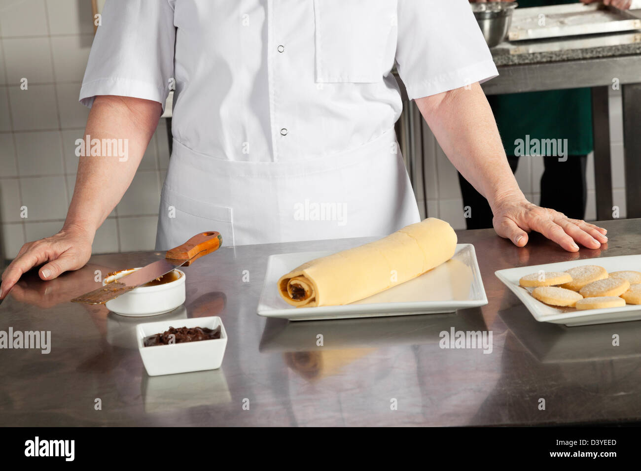 Female Chef With Chocolate Roll On Counter Stock Photo - Alamy