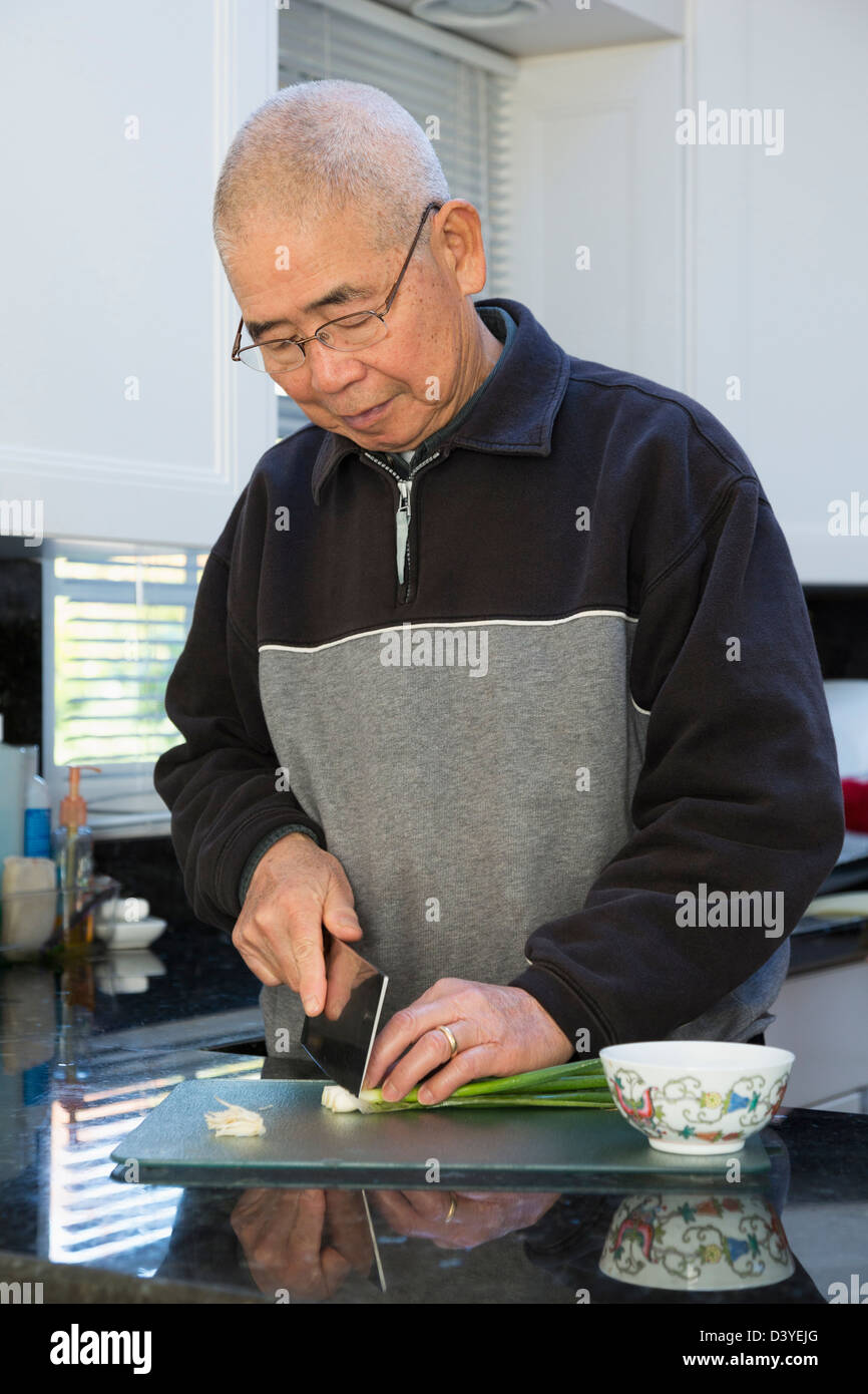 Chinese man chopping onions in kitchen Stock Photo - Alamy