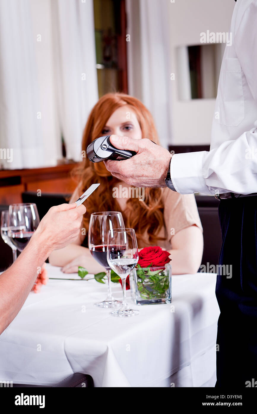 dinner in restaurant man and woman pay by credit card Stock Photo - Alamy