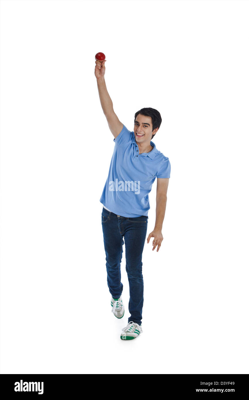 Portrait of a happy man bowling a cricket ball Stock Photo - Alamy