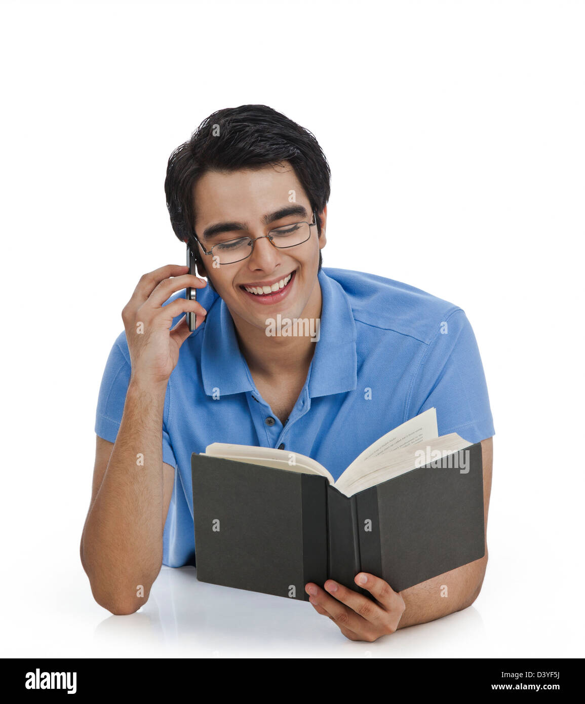 Happy man talking on a mobile phone while reading a book Stock Photo ...