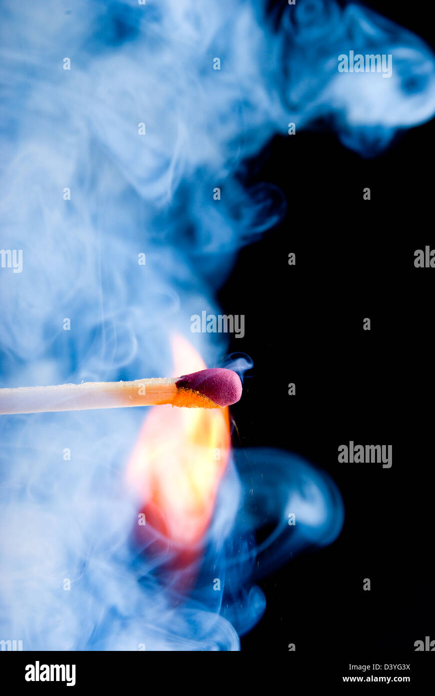 Burning match with blue smoke over black background Stock Photo - Alamy