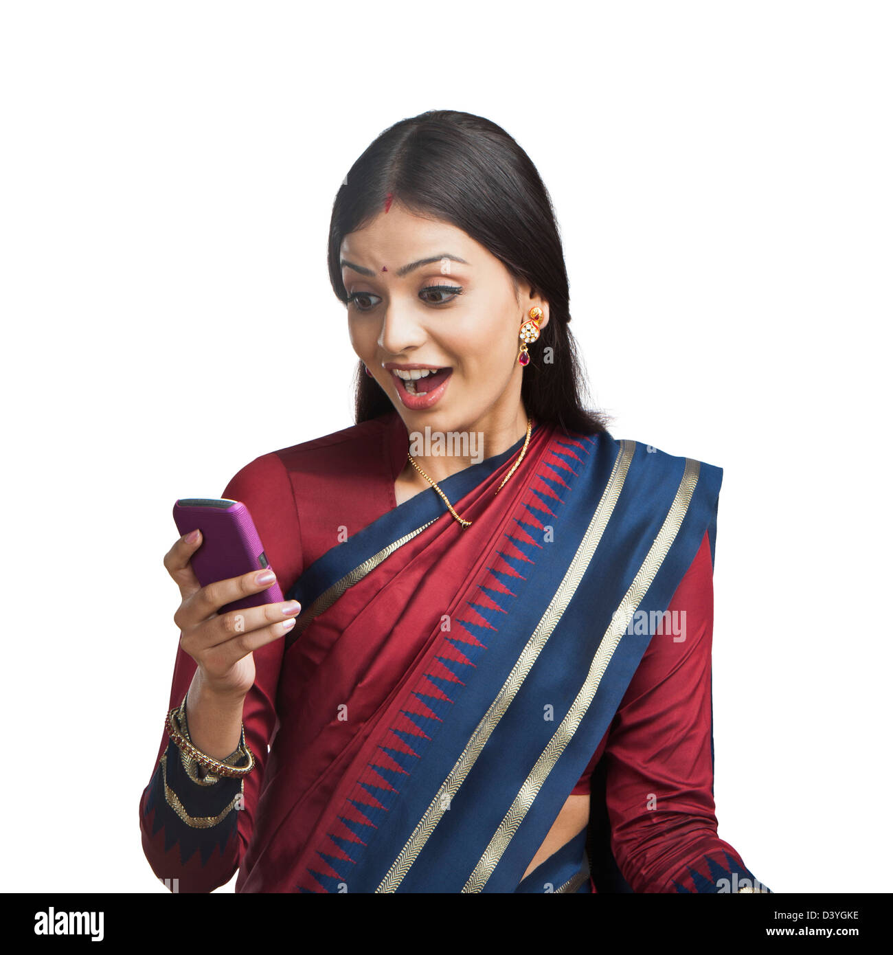Traditionally Indian woman using a cell phone and looking surprised ...