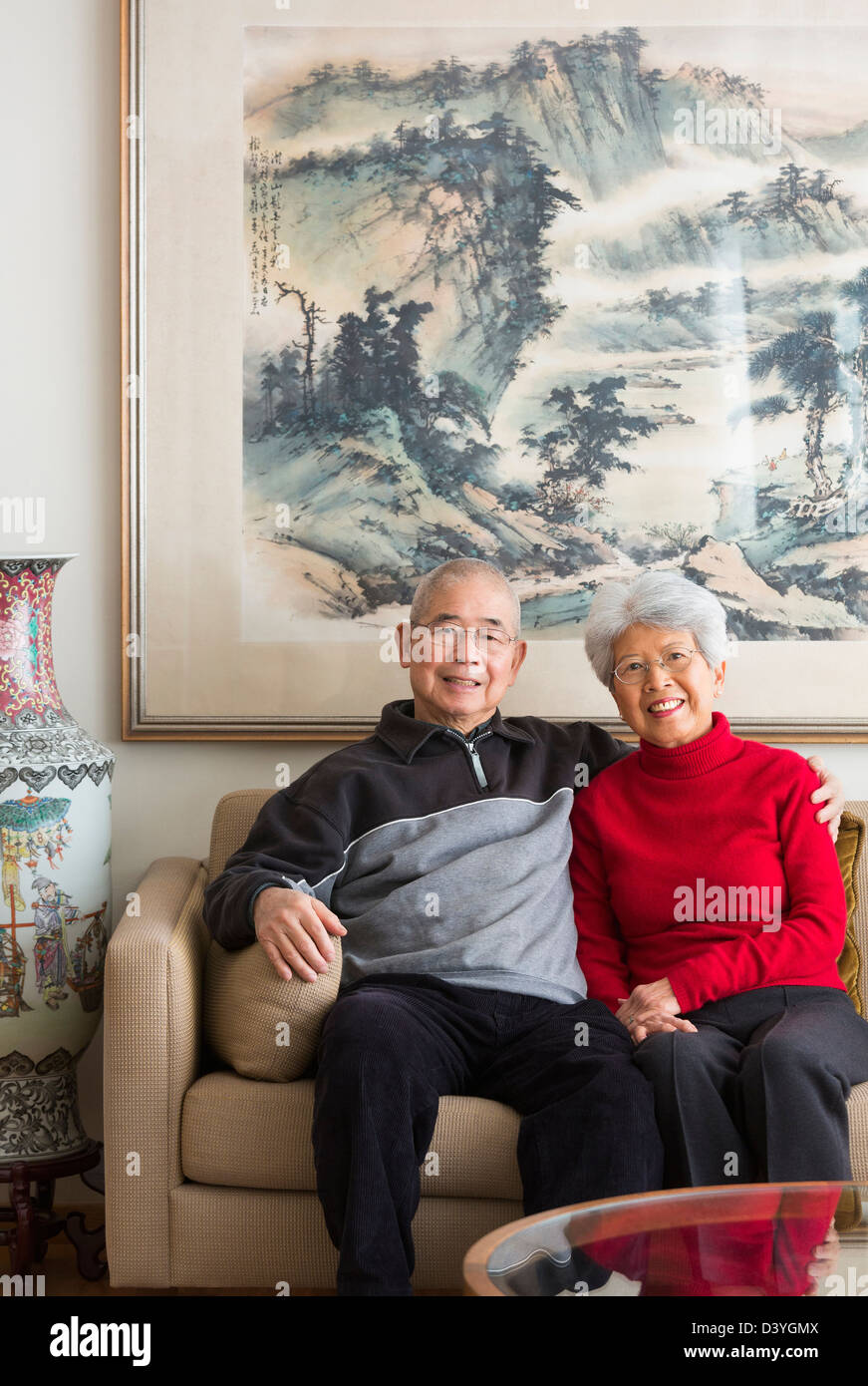 Chinese couple sitting on sofa Stock Photo - Alamy