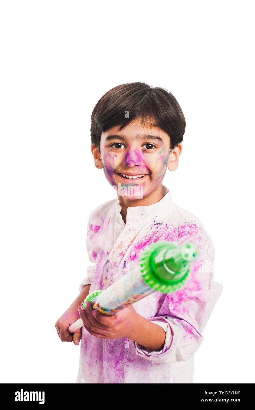 Boy celebrating Holi festival with pichkari Stock Photo - Alamy