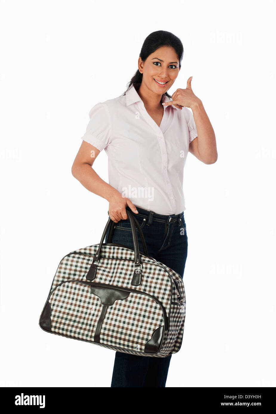 Woman carrying a bag and making a call sign Stock Photo - Alamy
