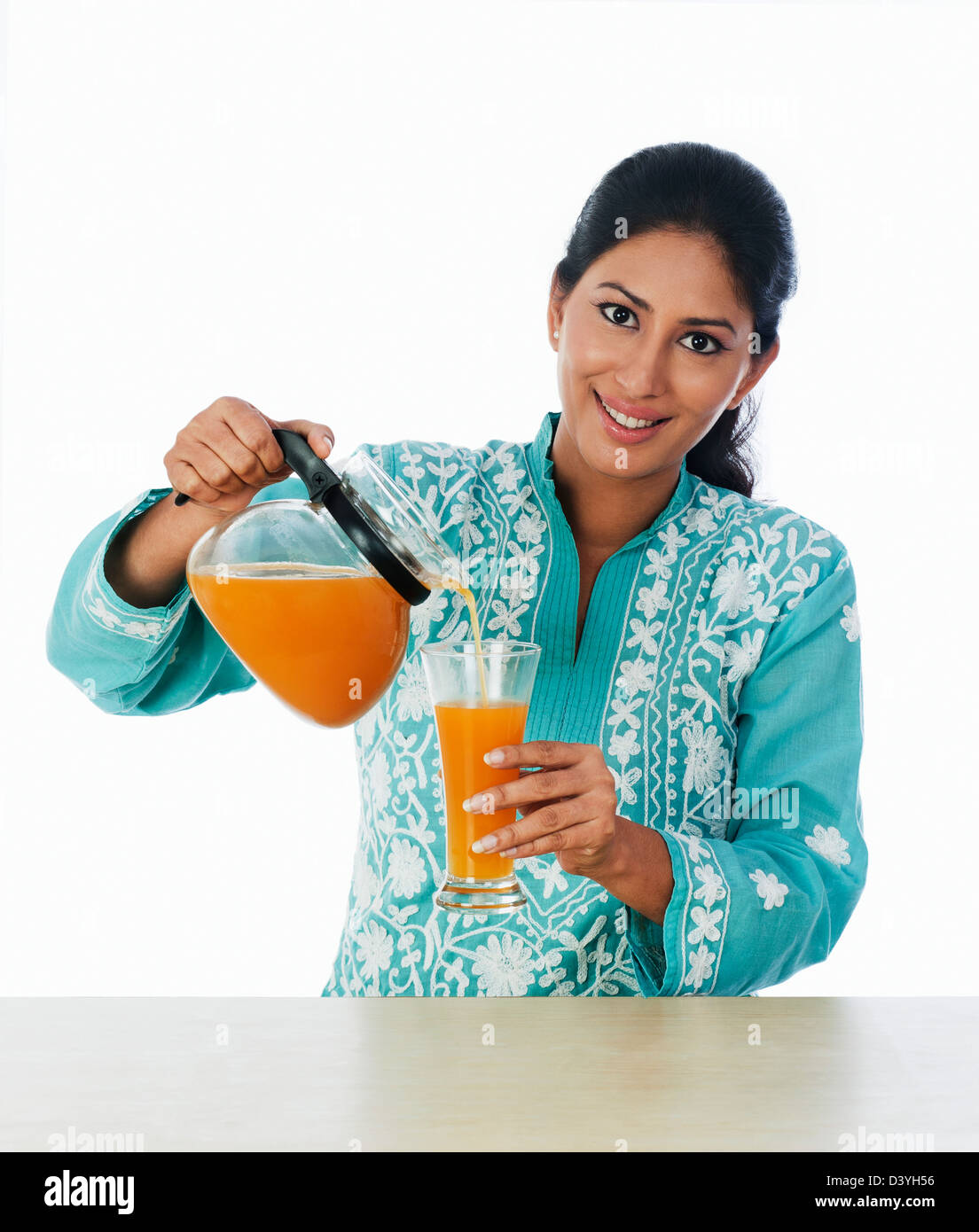 Woman pouring juice in a glass Stock Photo - Alamy