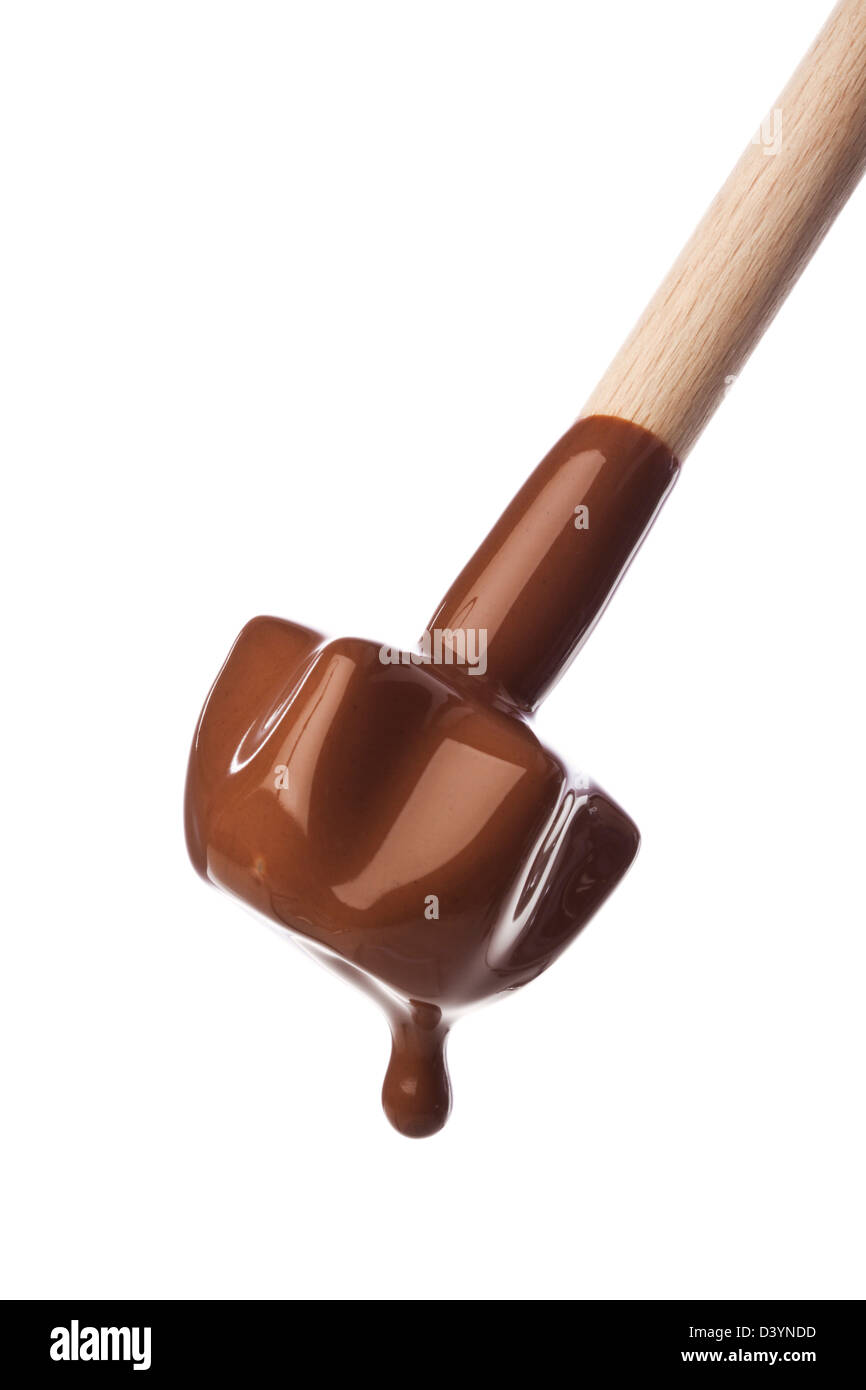 closeup of liquid chocolate dripping from a wooden querl isolated on ...