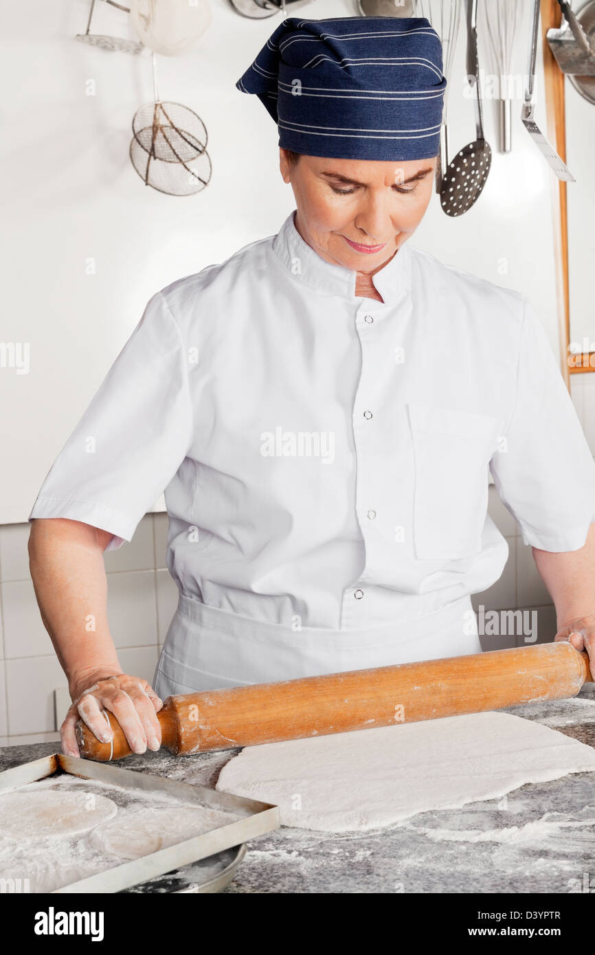 Female Chef Rolling Dough On Counter Stock Photo - Alamy