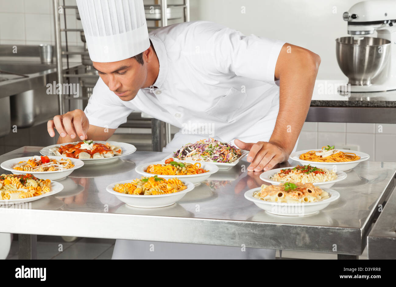 Chef Garnishing Dishes At Counter Stock Photo - Alamy