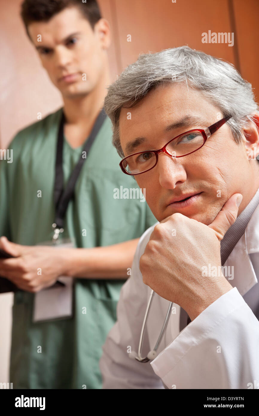 Male Doctor With Hand On Chin Stock Photo - Alamy