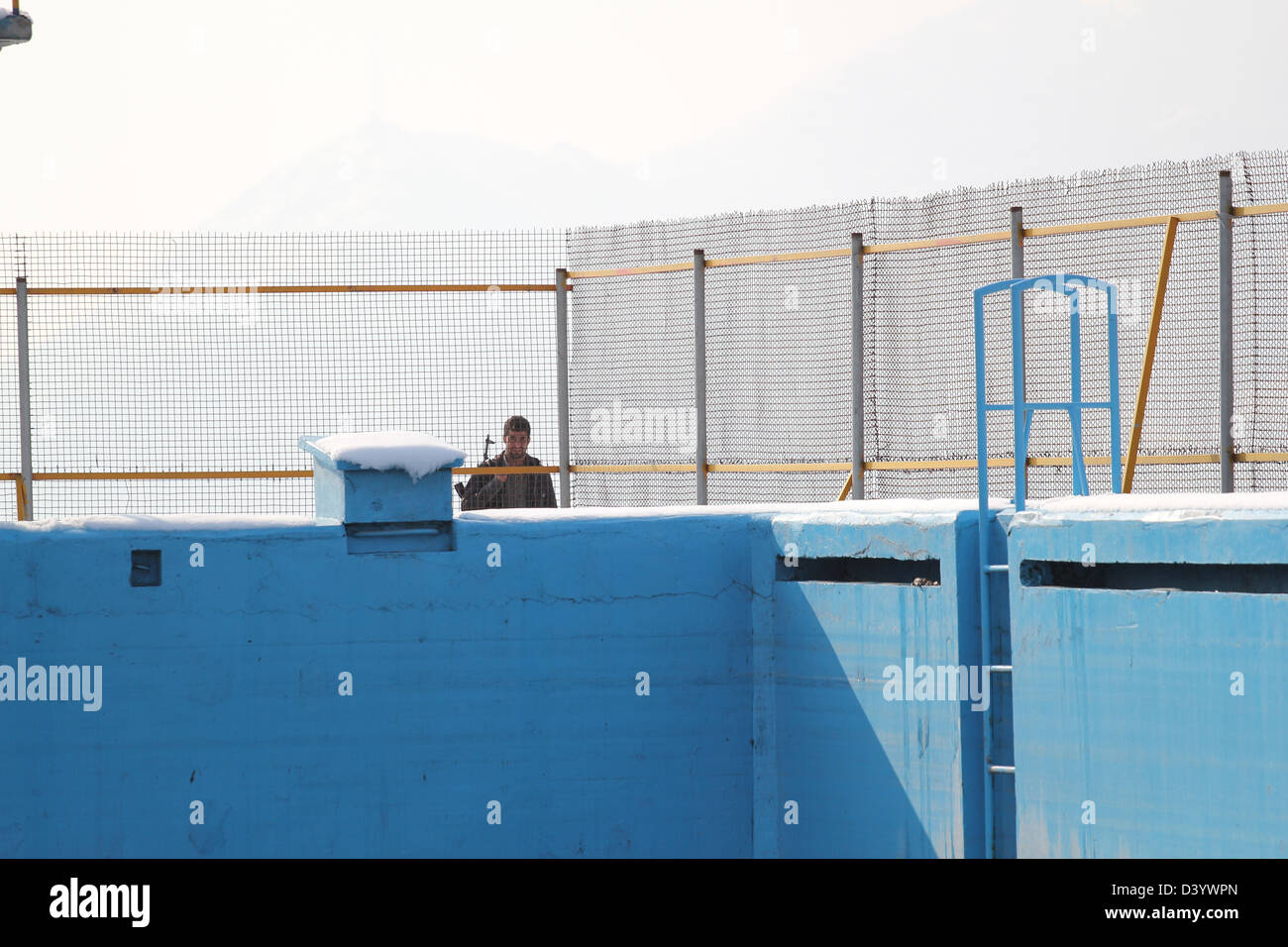 An Afghan police man looks into a deserted swimming pool in Kabul, a ...