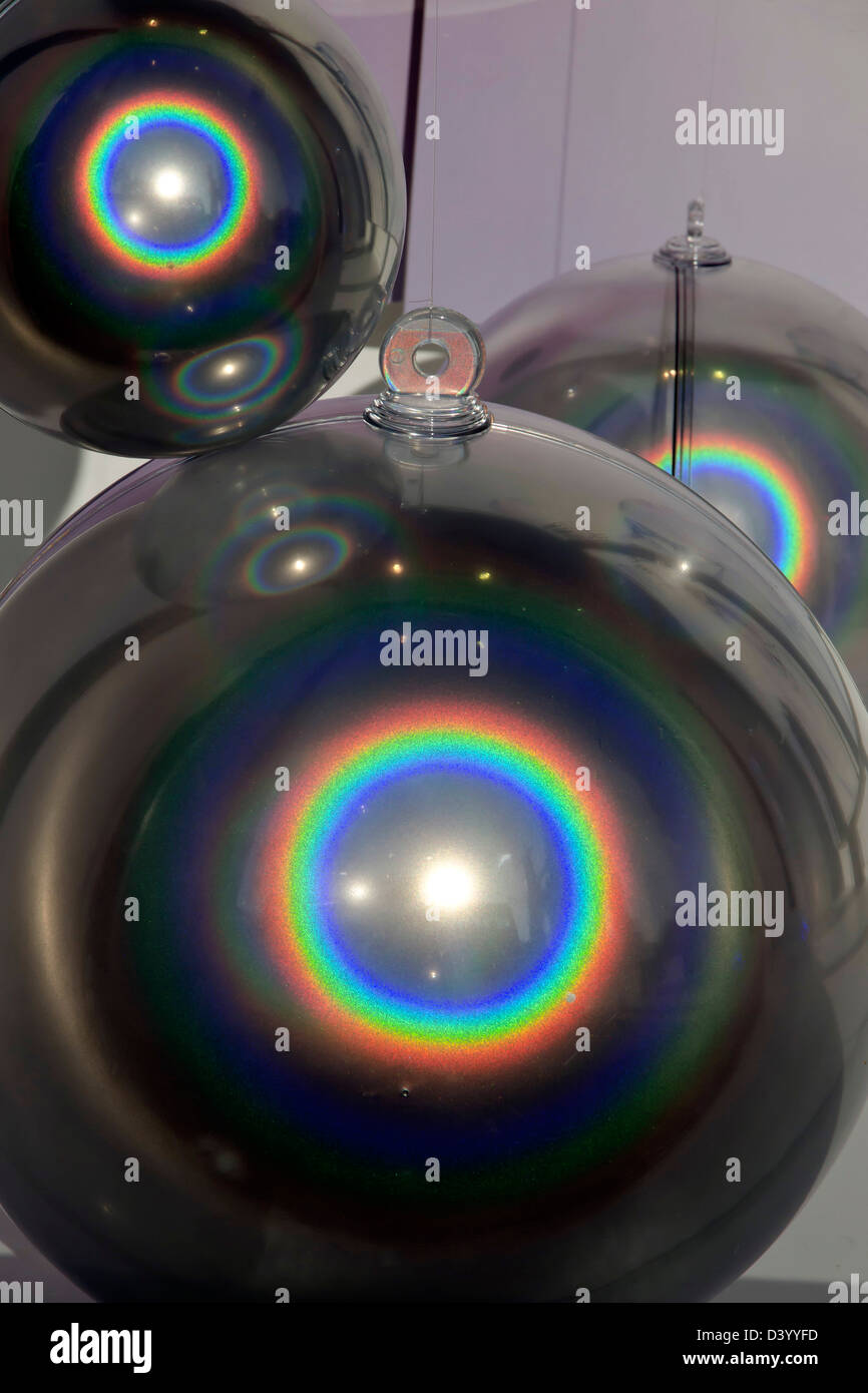 Rainbow colours created by the sun shining on large perspex balls in a ...