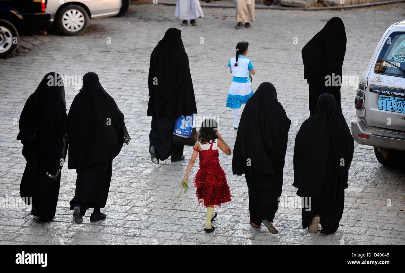 Six Muslim Women in traditional balck dress with heads covered with two ...