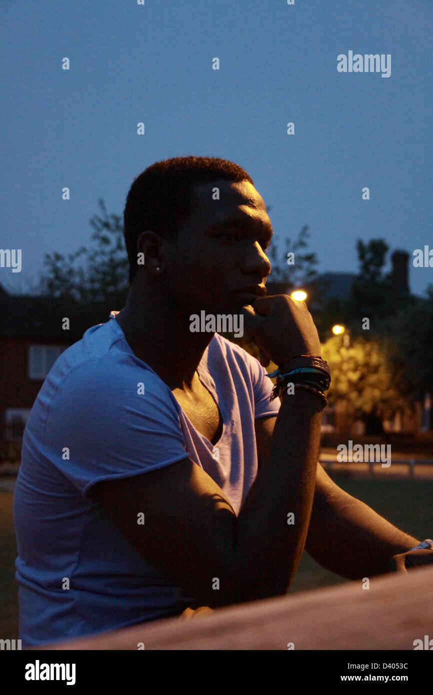 Black man resting his arm in a park at night Stock Photo - Alamy
