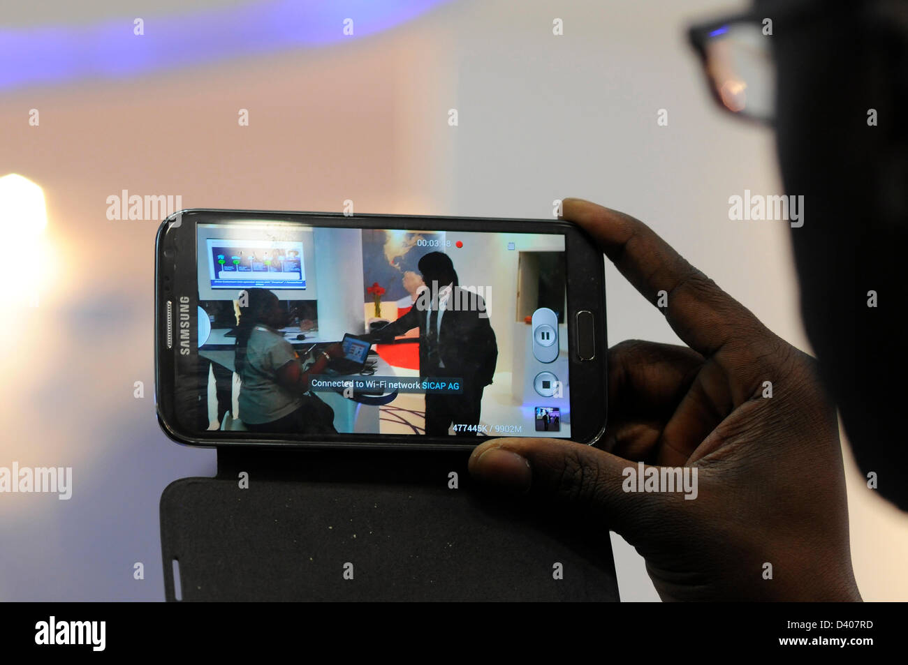 a man recording a video with his smart phone of the stand at the Mobile ...