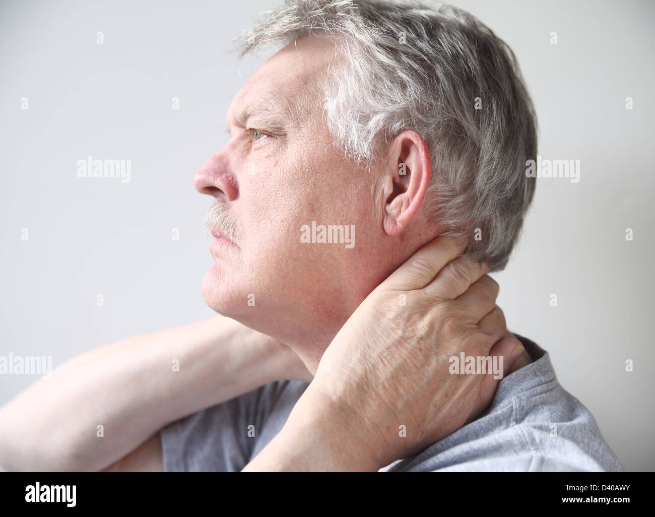 senior man with both hands on his neck Stock Photo - Alamy