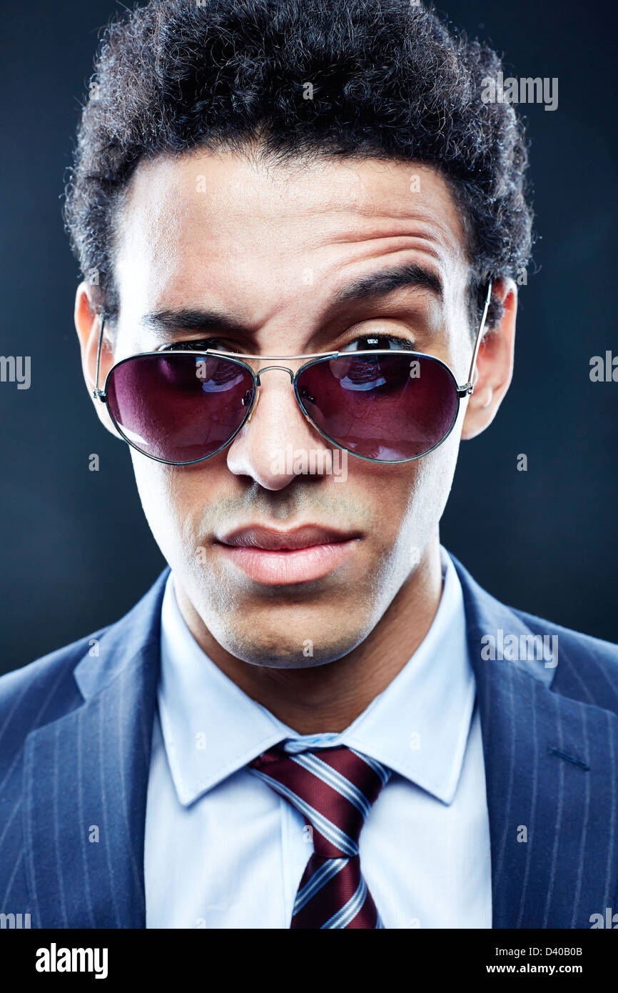Portrait of doubtful man in sunglasses looking at camera Stock Photo ...