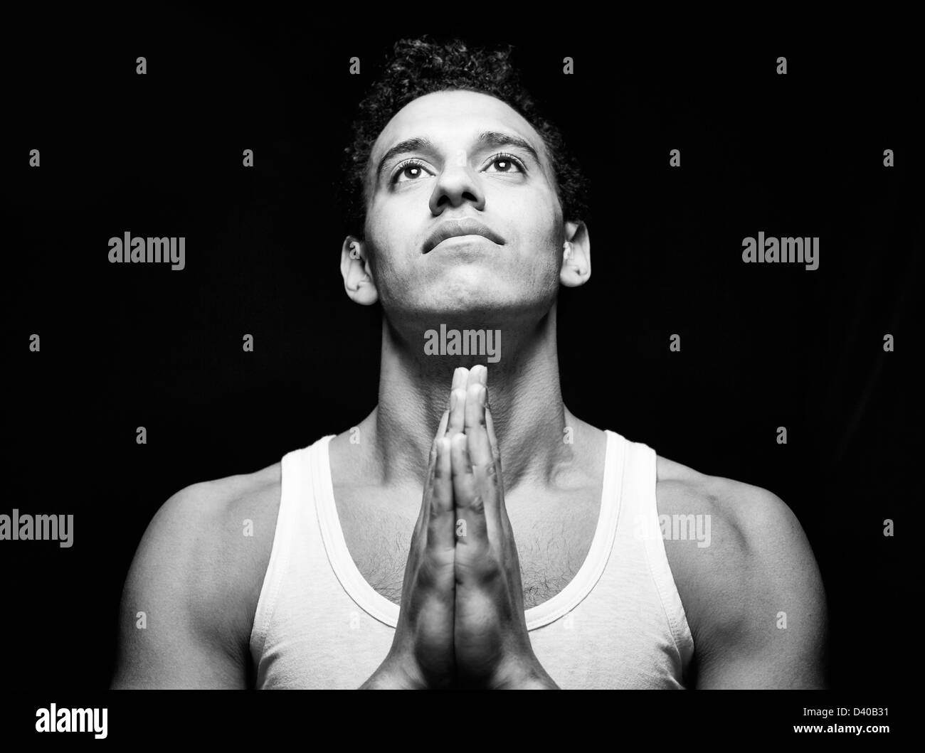 Handsome young man praying in Black and White Stock Photos & Images - Alamy