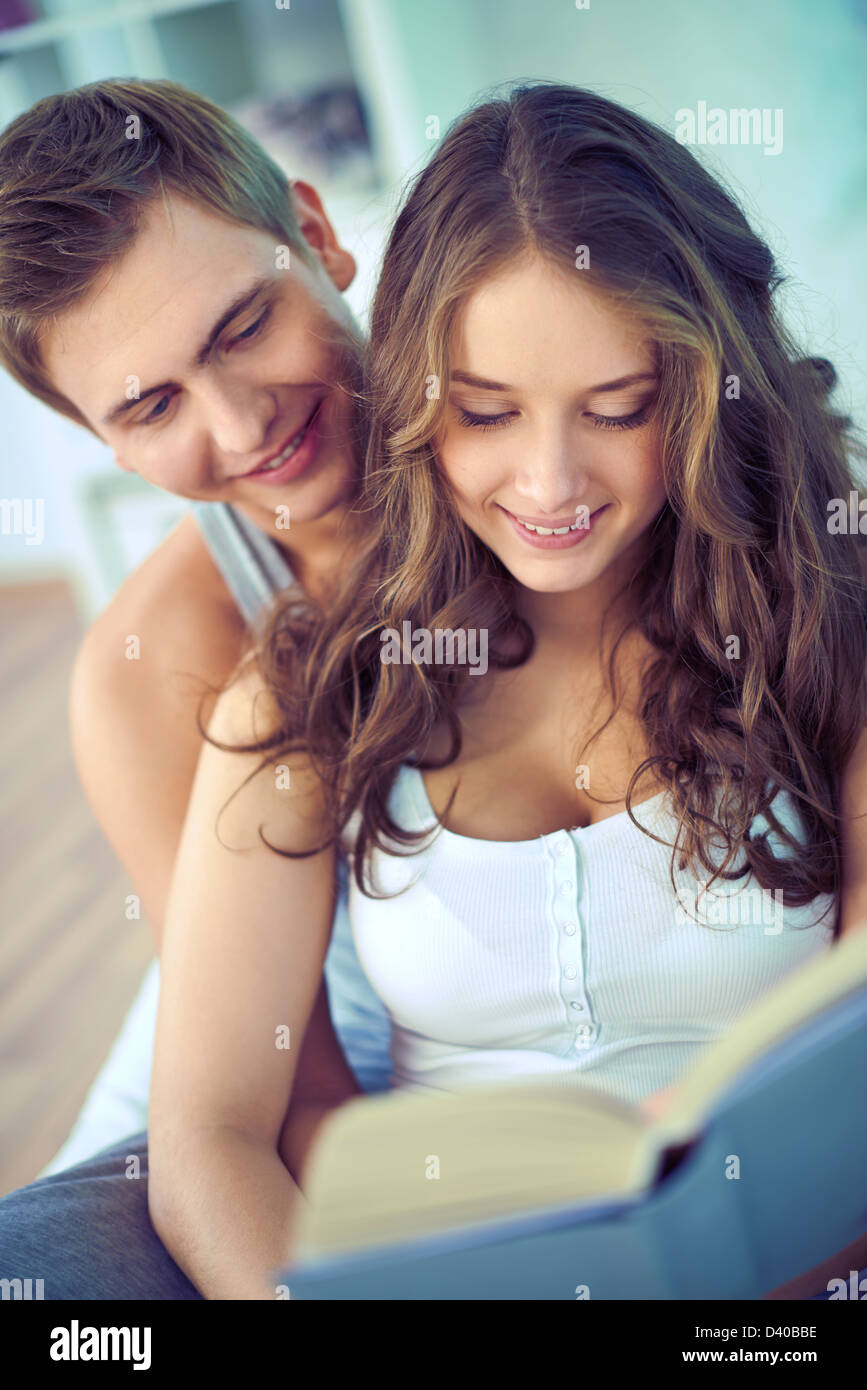Affectionate couple reading book together Stock Photo - Alamy