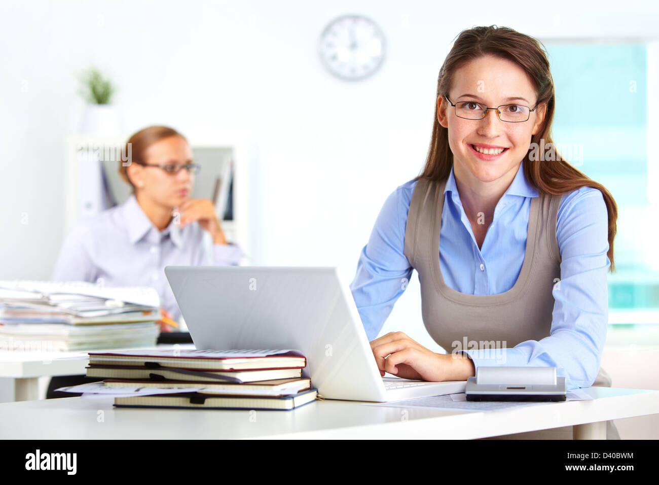 Portrait of pretty secretary using laptop in office Stock Photo - Alamy
