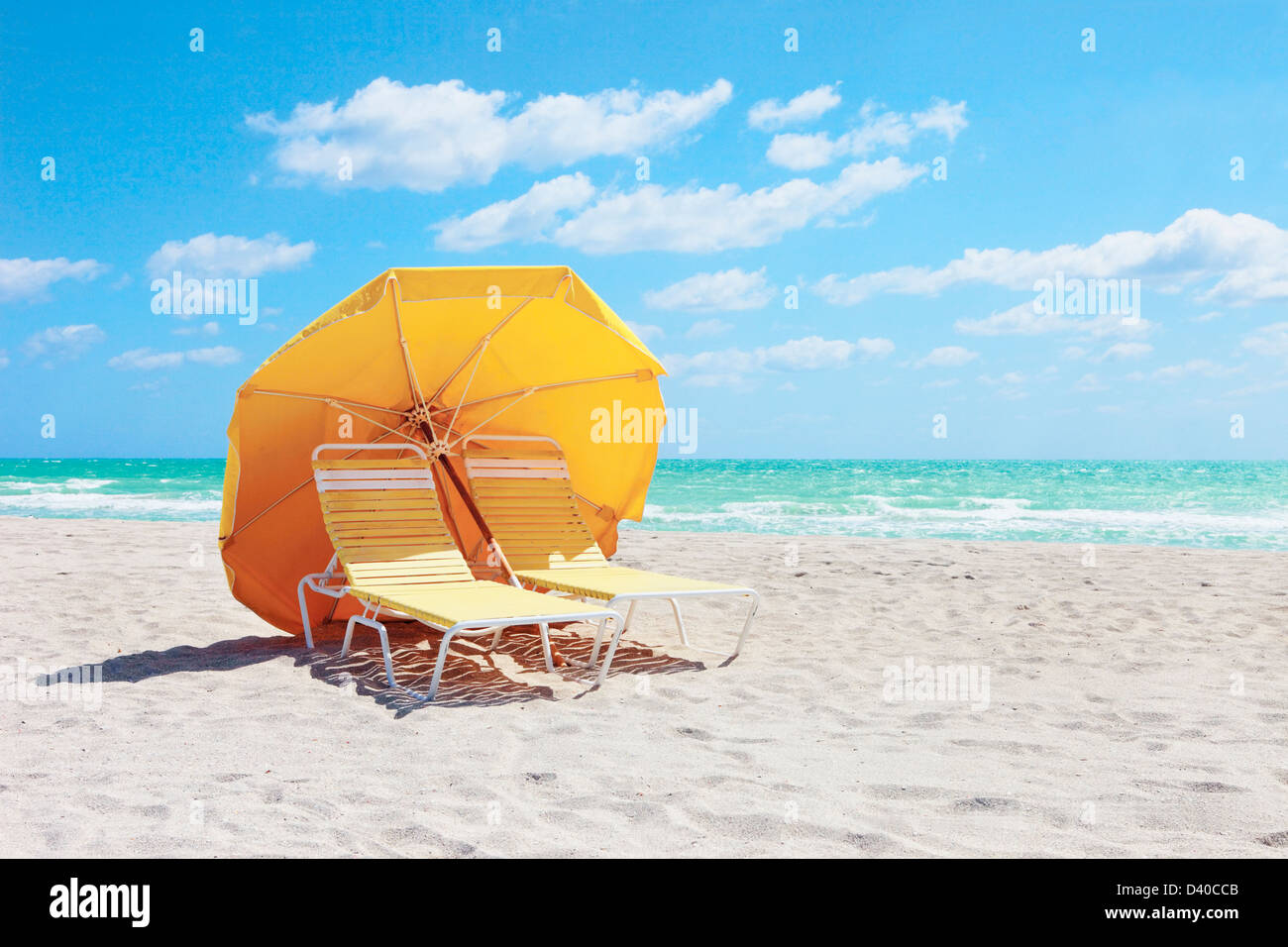 A pair of sunbathing chairs and beach umbrella Stock Photo - Alamy
