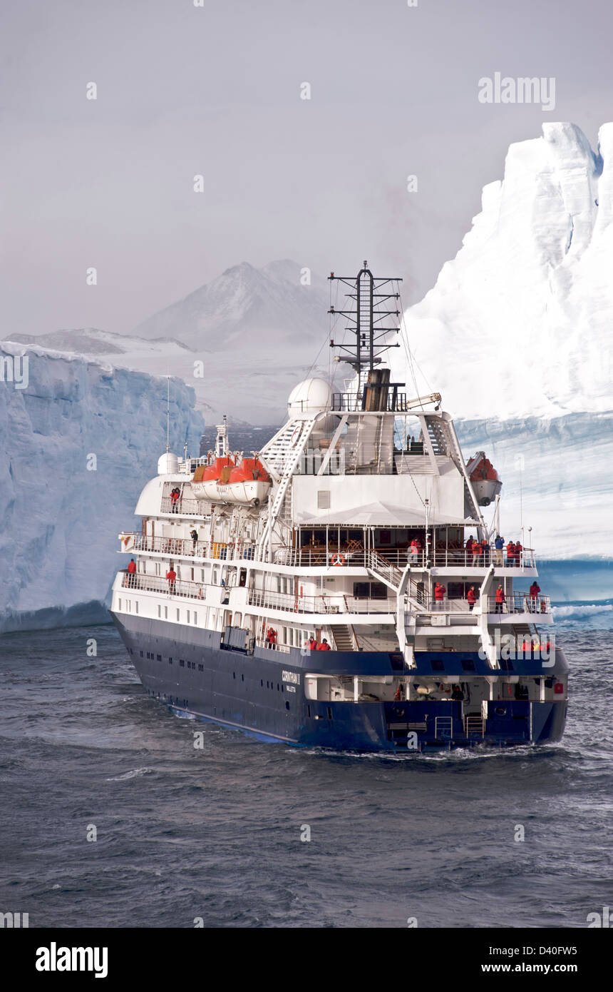 The cruise ship Corinth 2 in front of a large tabular iceberg in the ...