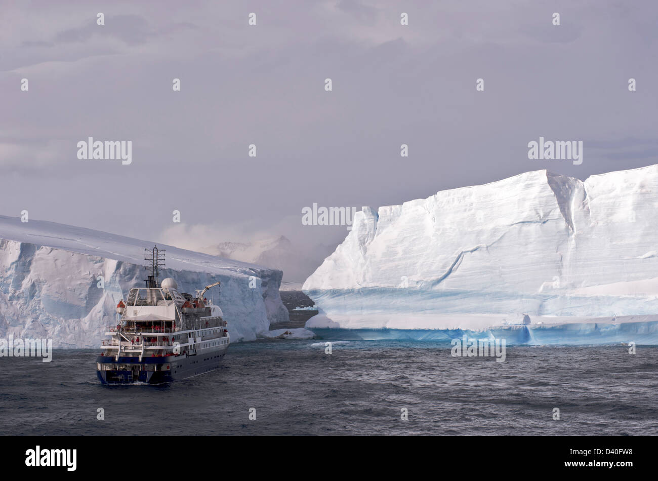The cruise ship Corinth 2 in front of a large tabular iceberg in the ...