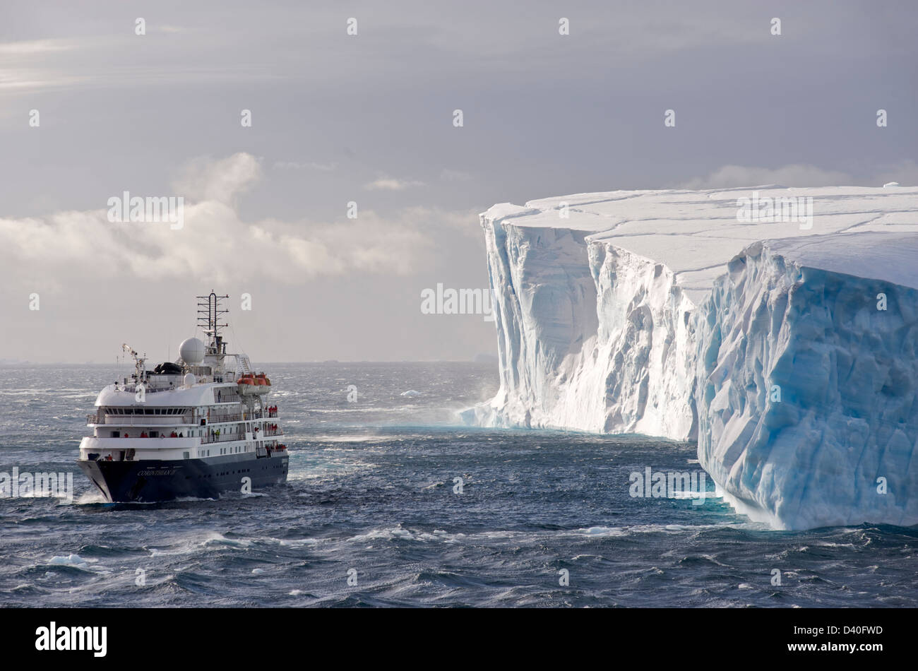 The cruise ship Corinth 2 in front of a large tabular iceberg in the ...
