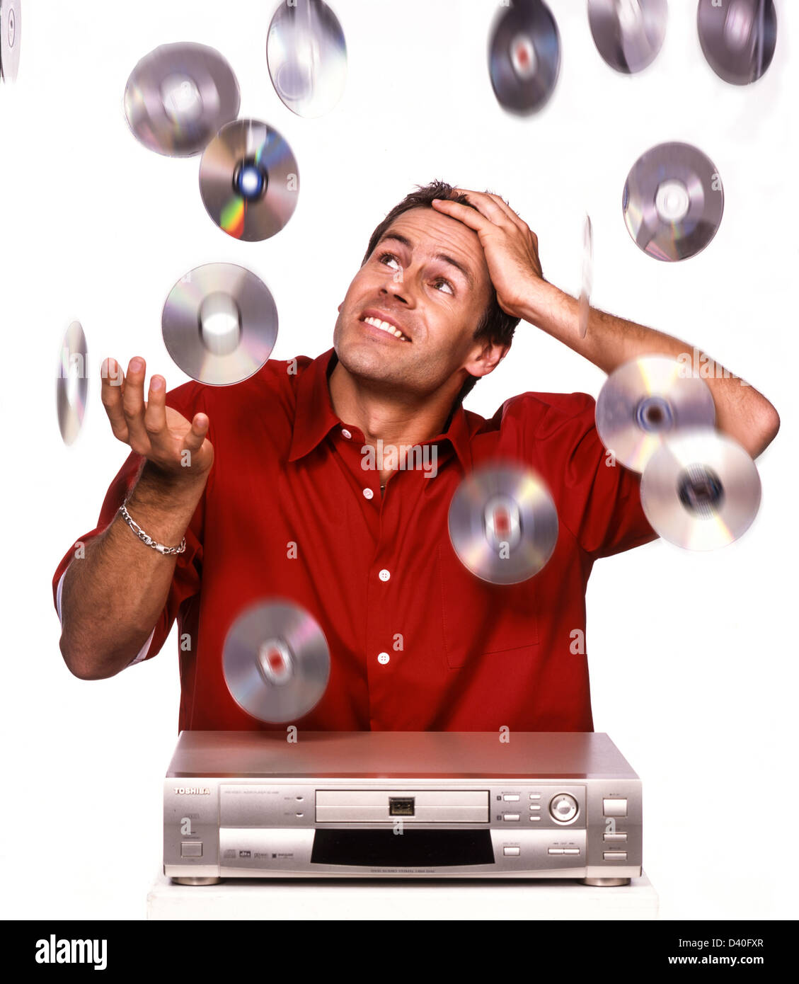 Studio portrait of young good looking man with CD's and DVD's in a red ...