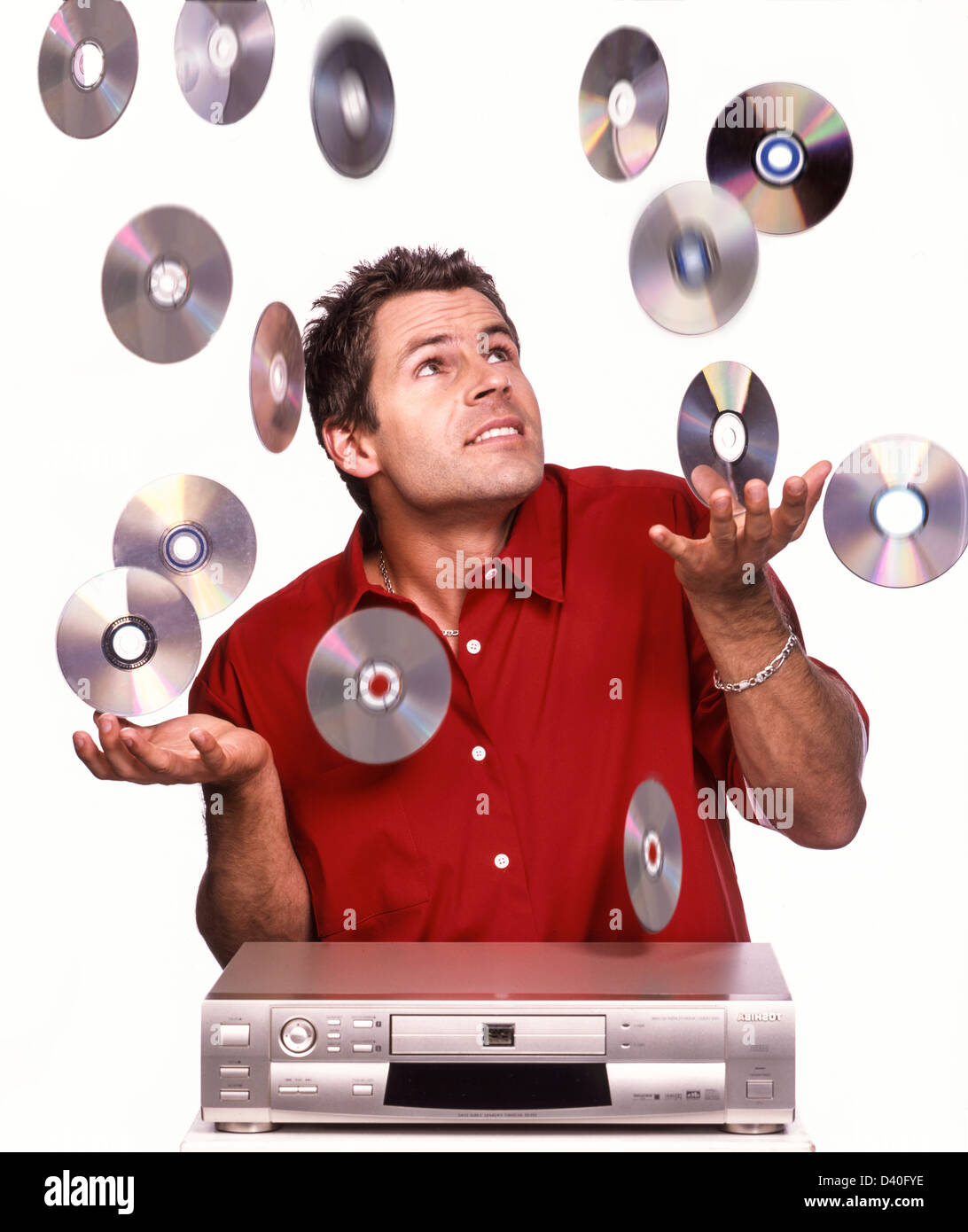 Studio portrait of young good looking man with CD's and DVD's in a red ...