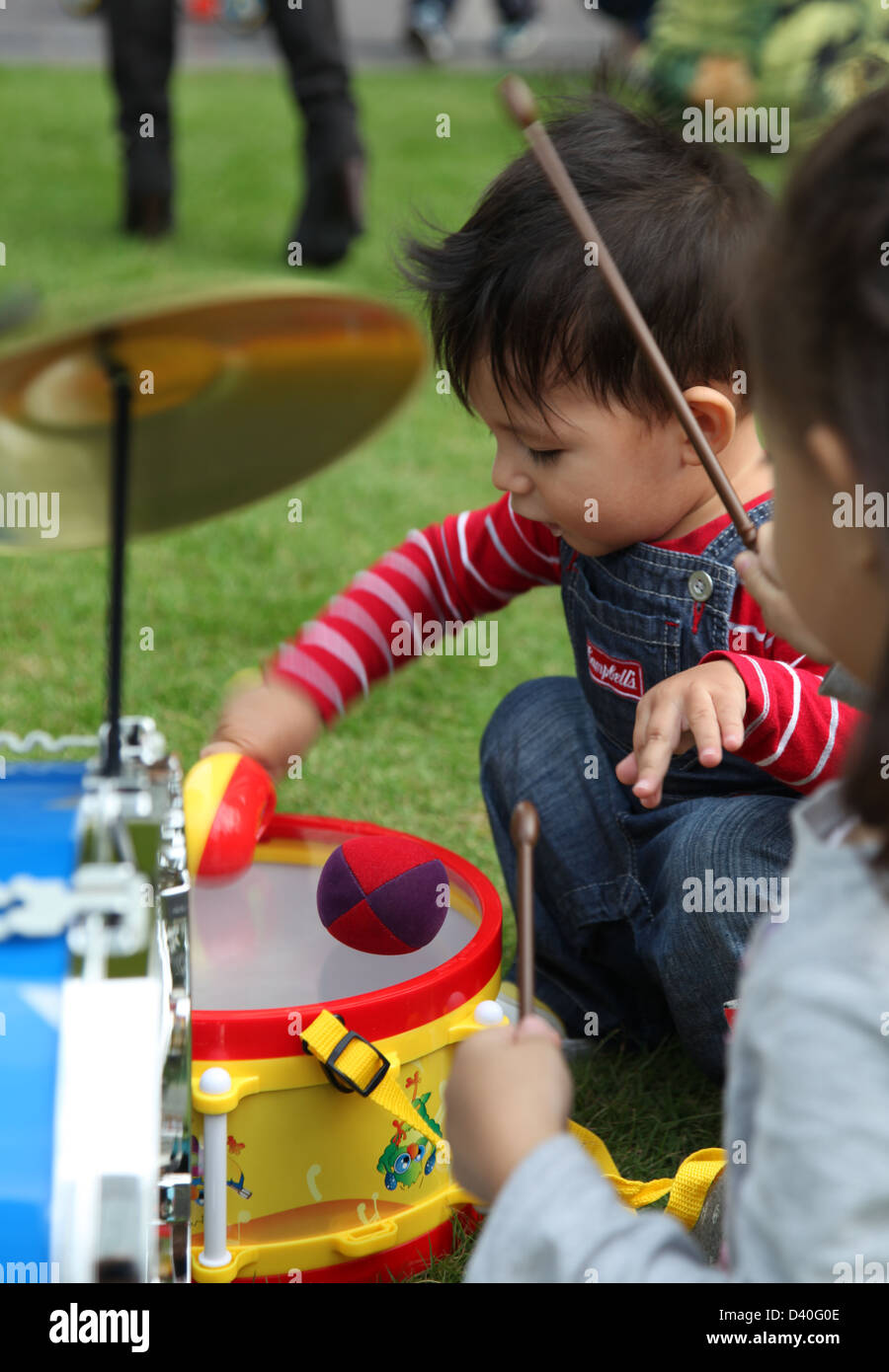 It's a photo of a young child boy who is playing drums on a kid toy ...