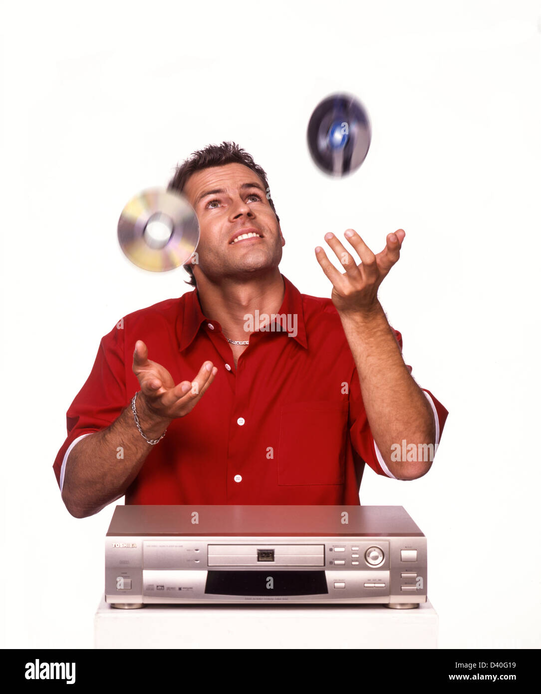 Studio portrait of young good looking man with CD's and DVD's in a red ...