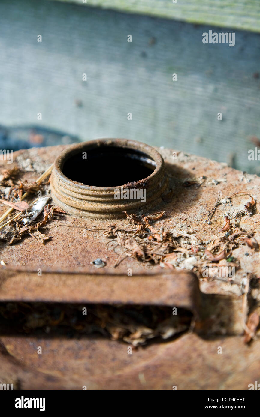 Close up of rusty oil can showing texture against blue/grey background ...