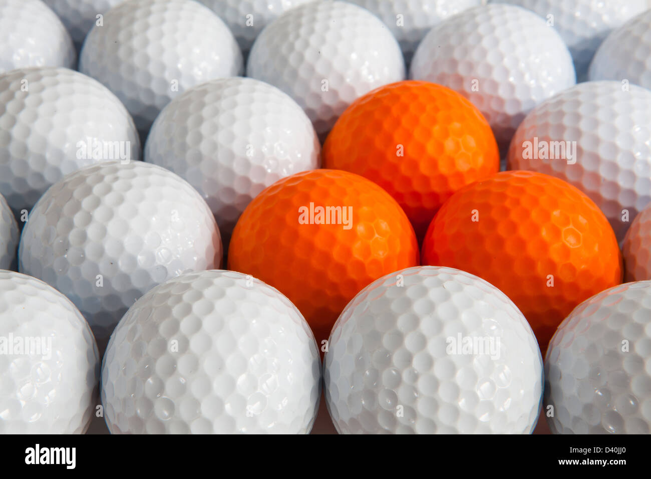 White and orange golf balls Stock Photo - Alamy