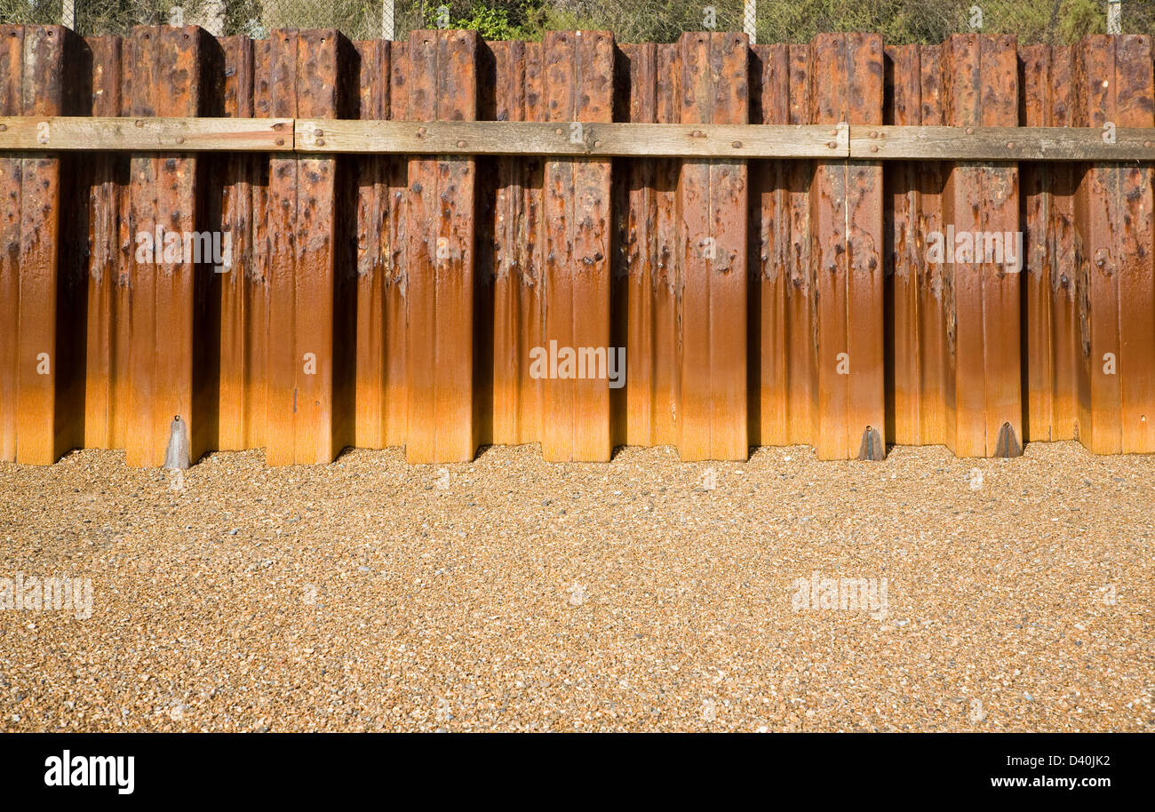 Rusty steel piling sea wall defences and shingle beach near Bawdsey ...