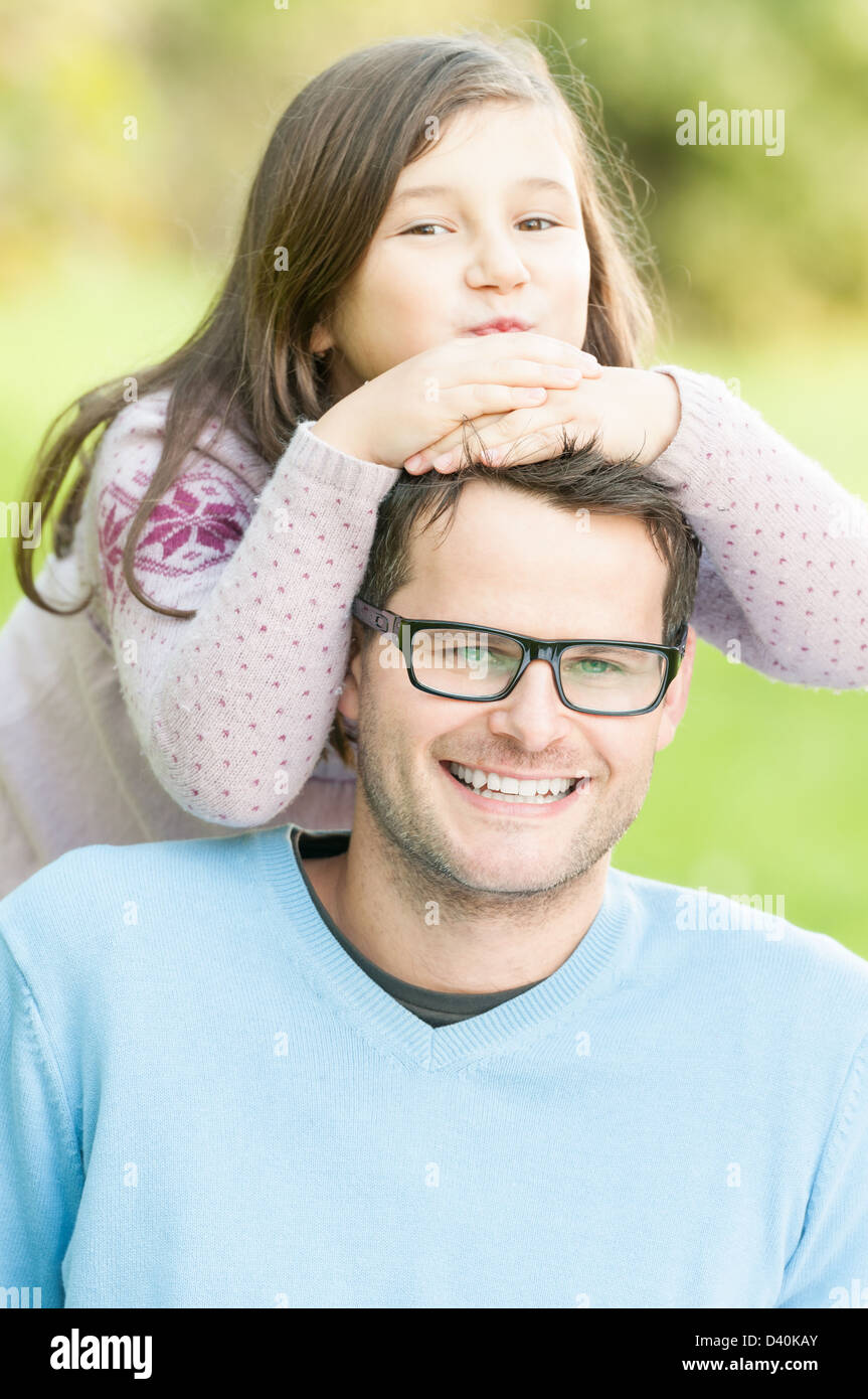 Daughter keeping her hands on father's head. Happy kid and dad having ...