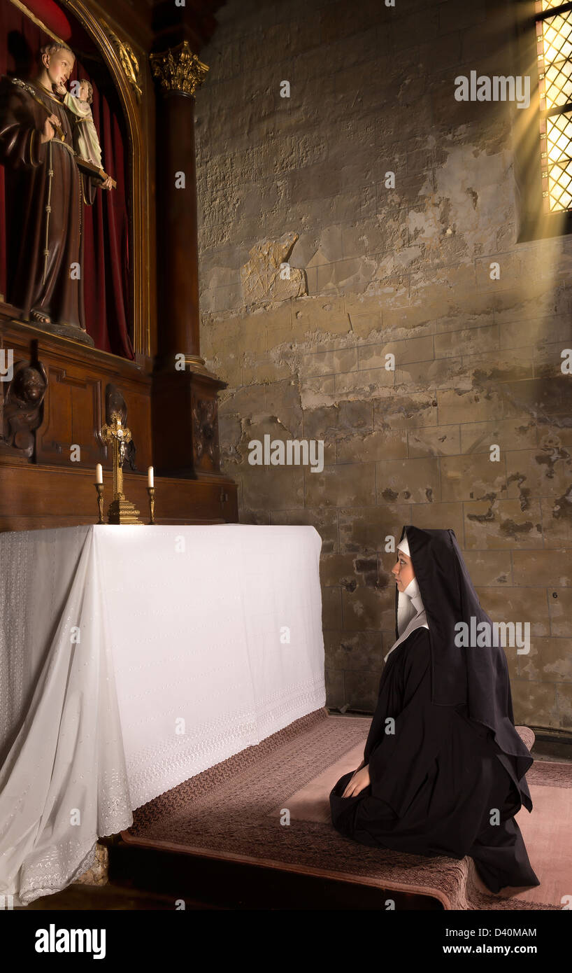 17th century church interior and a nun in prayer at the altar Stock ...
