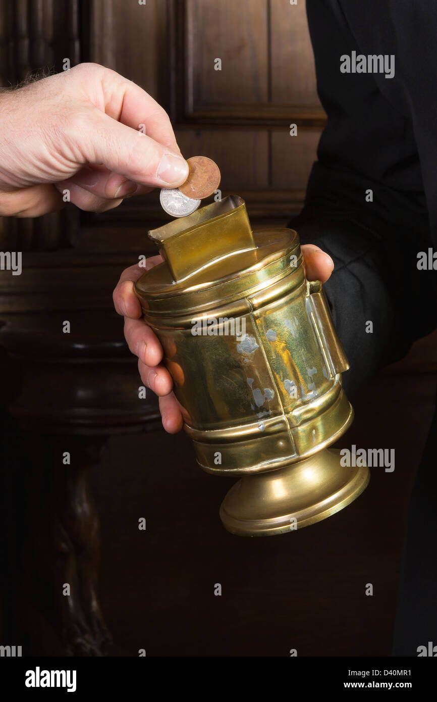 Hand giving coins to a priest collecting in church Stock Photo - Alamy
