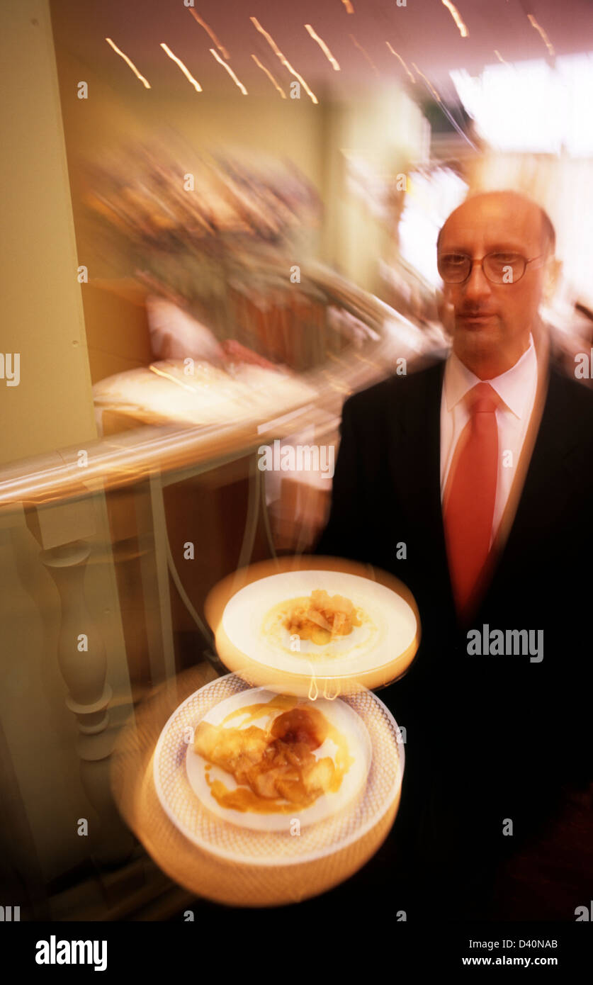 A waiter brings plates to a table in a London restaurant Stock Photo ...