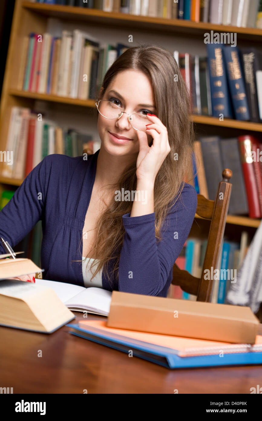 Portrait of young student studying among lot of books Stock Photo - Alamy