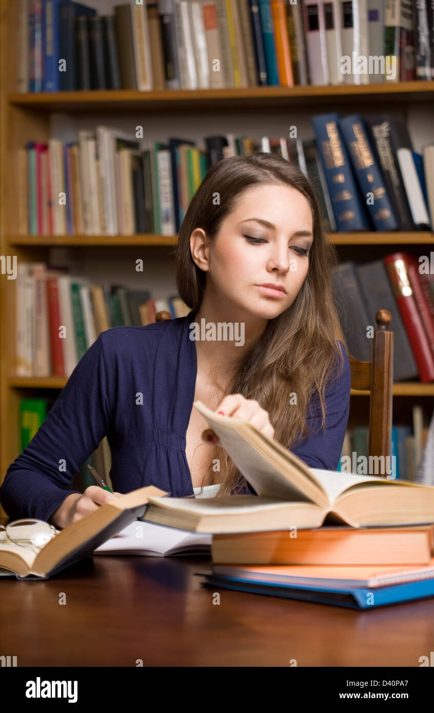 Portrait of young student studying among lot of books Stock Photo - Alamy